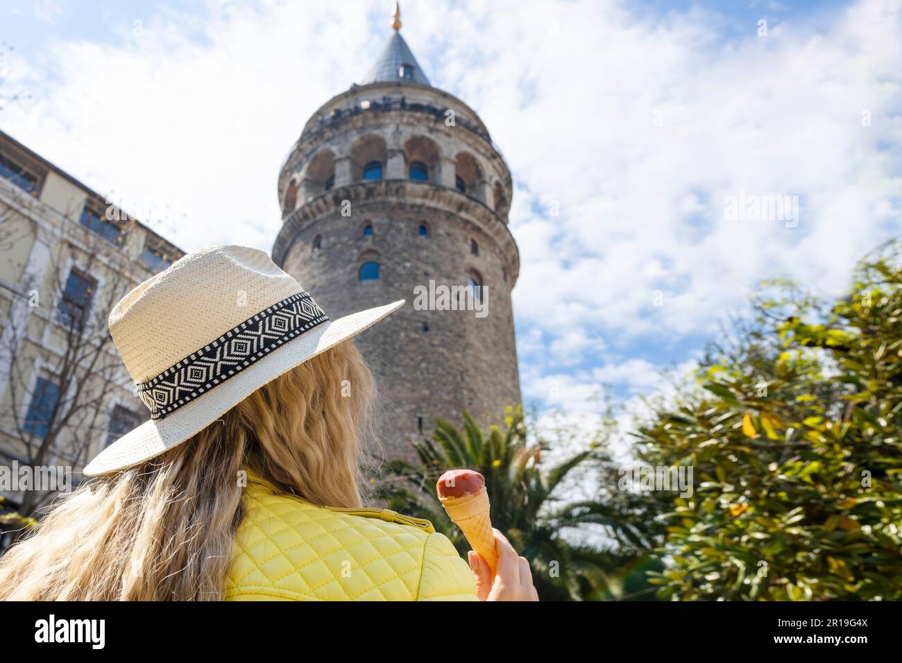 Beautiful young tourist girl in fashionable clothes poses with view of ...