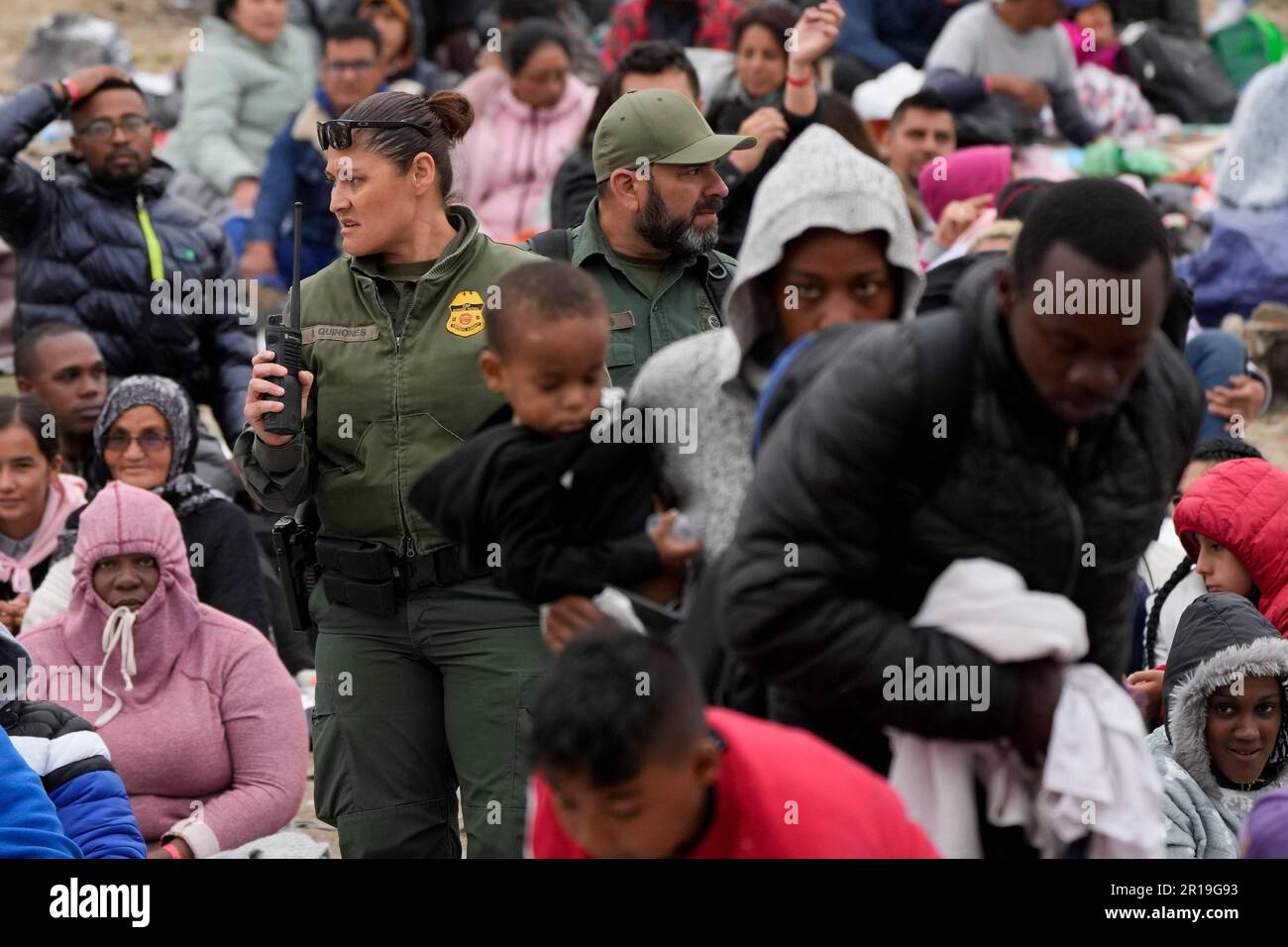U.S. Border Patrol agents move through a crowd of migrants that have ...