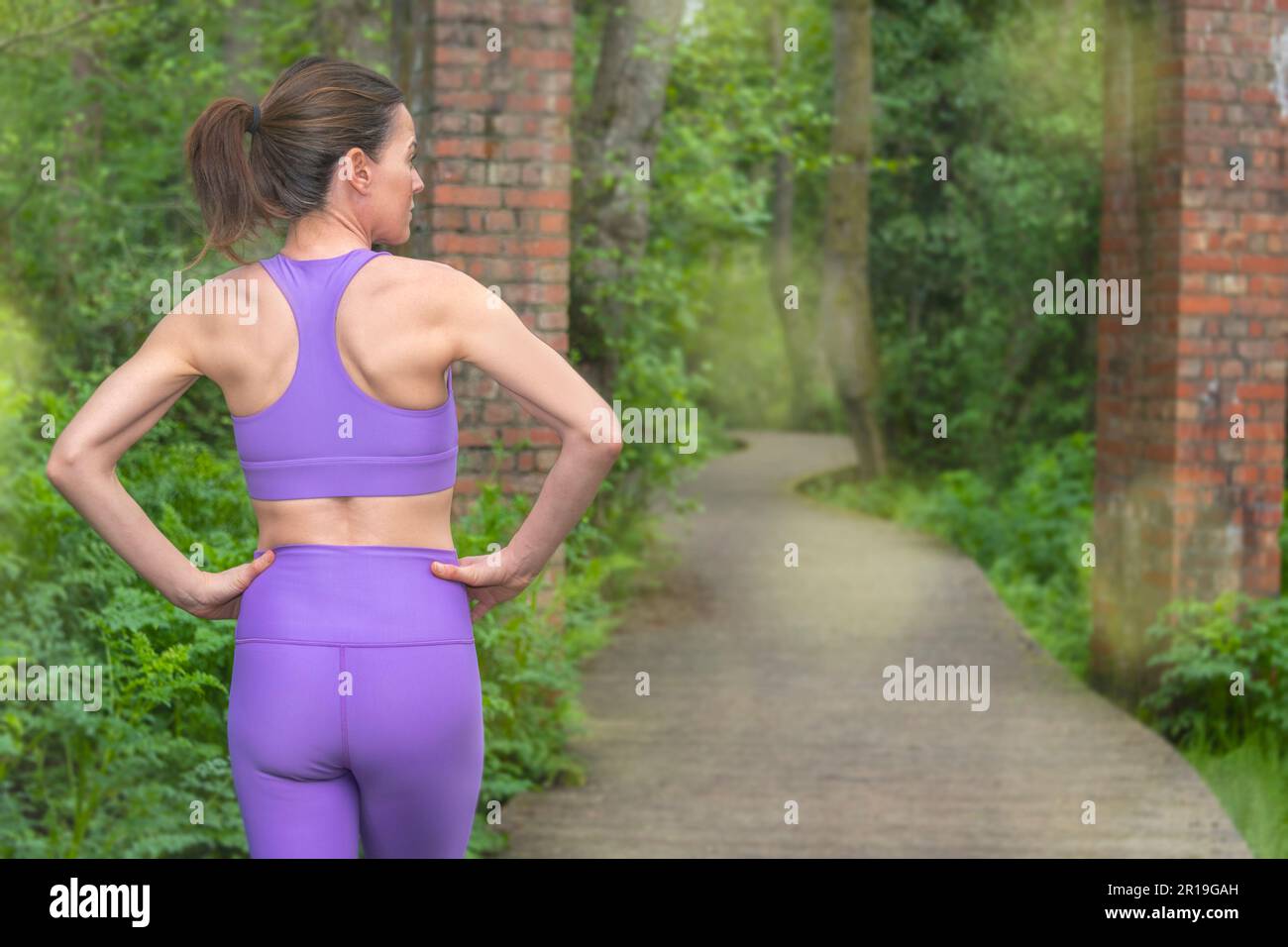 Rear view of woman jogger with fit body wearing sportswear standing ...