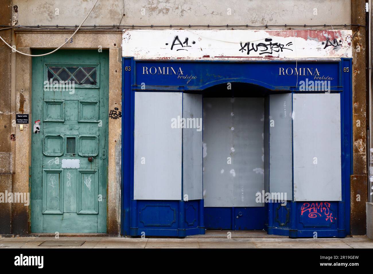 Green wooden door and boarded up Romina boutique shop on Praça de ...