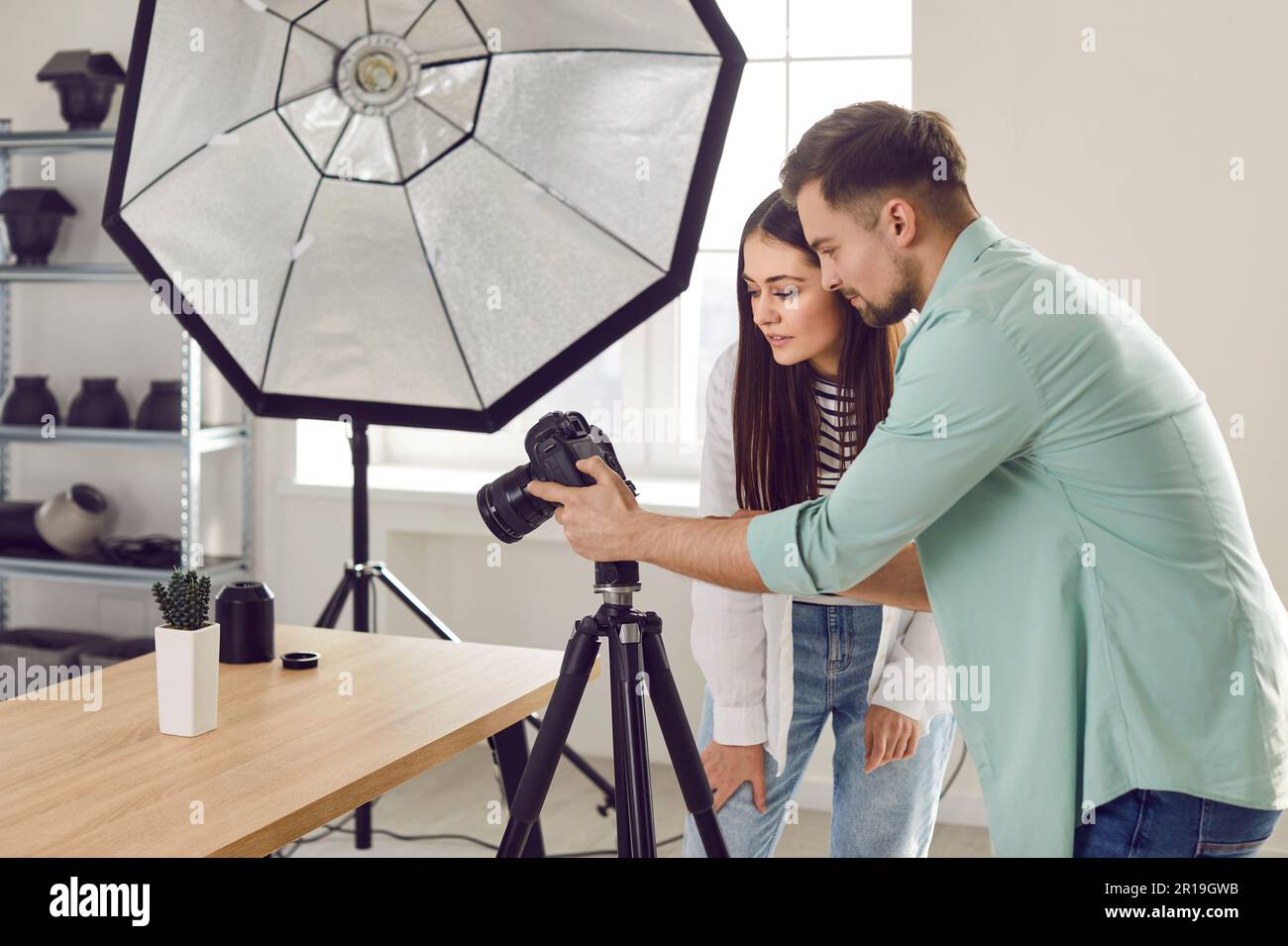 Photographer and model choosing photos from photo shoot together Stock ...