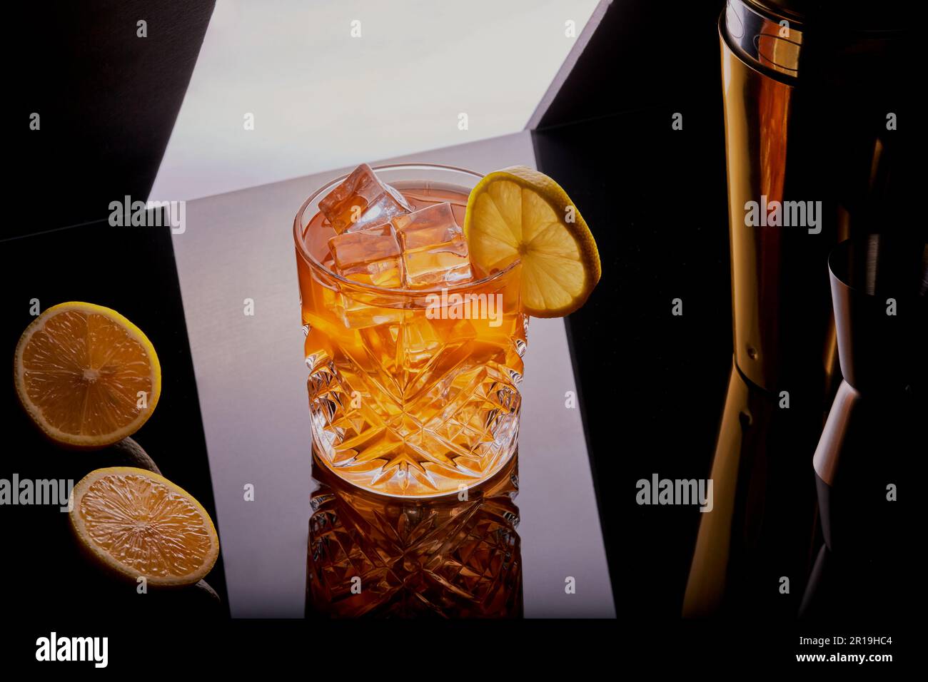 whisky cocktail garnished with a slice of lemon resting on a bar ...