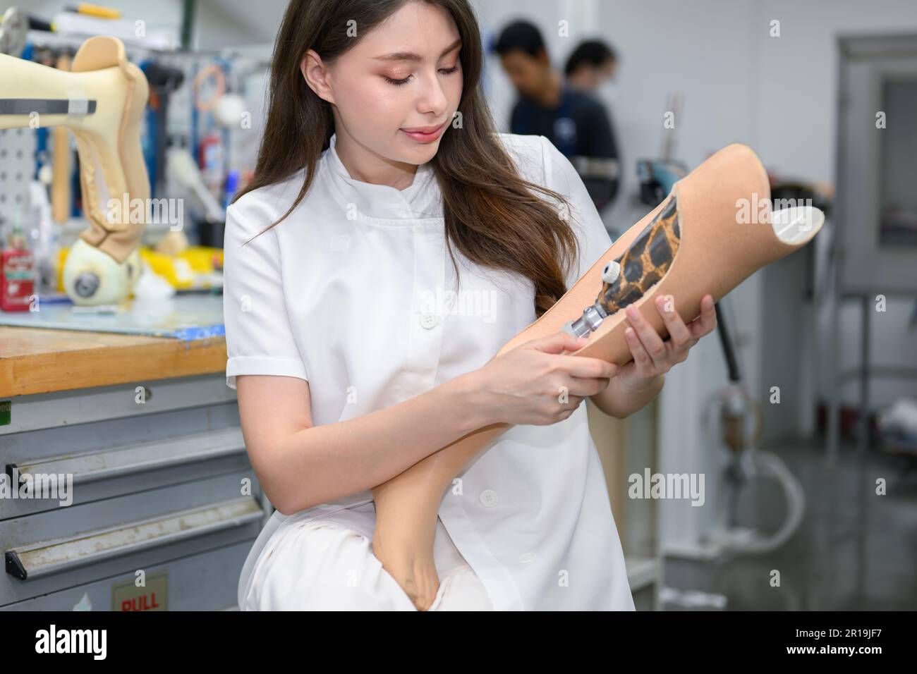 Technician holding prosthetic leg checking and working in laboratory ...