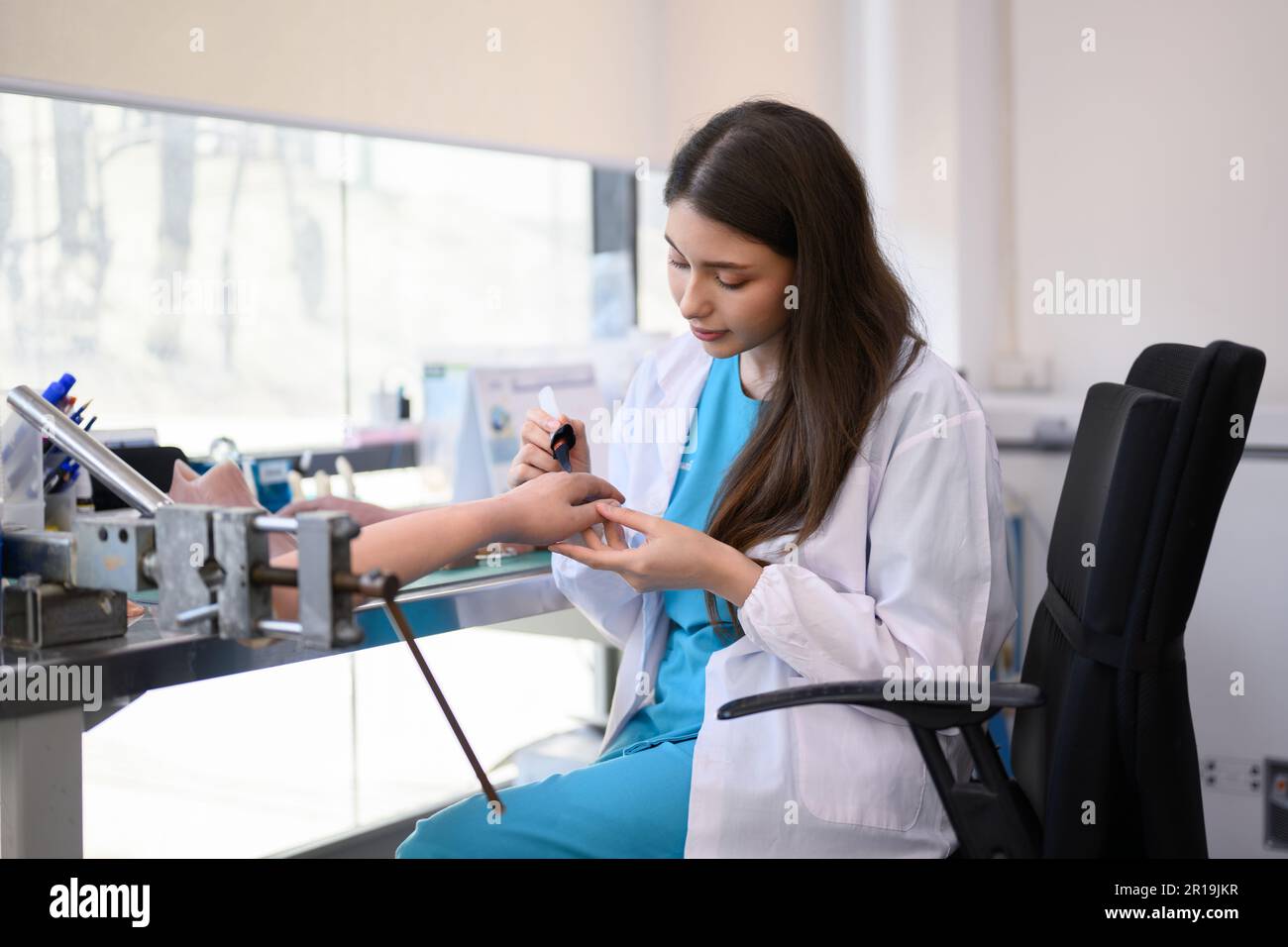 Technician making prosthetic device using grinder to smooth socket ...