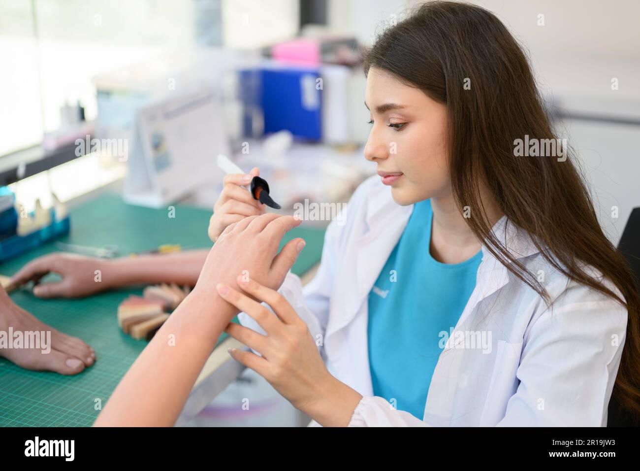 Technician making prosthetic device using grinder to smooth socket ...
