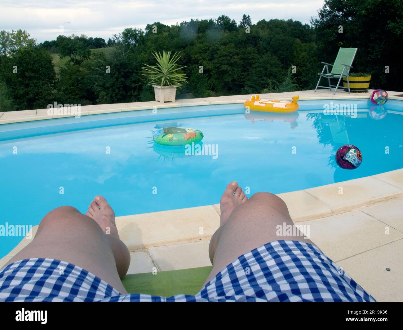 one man laying by swimming pool dordogne region france Stock Photo - Alamy