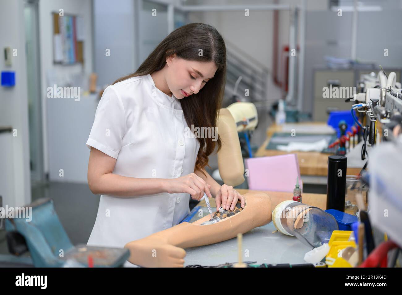 Technician holding prosthetic leg checking and working in laboratory ...