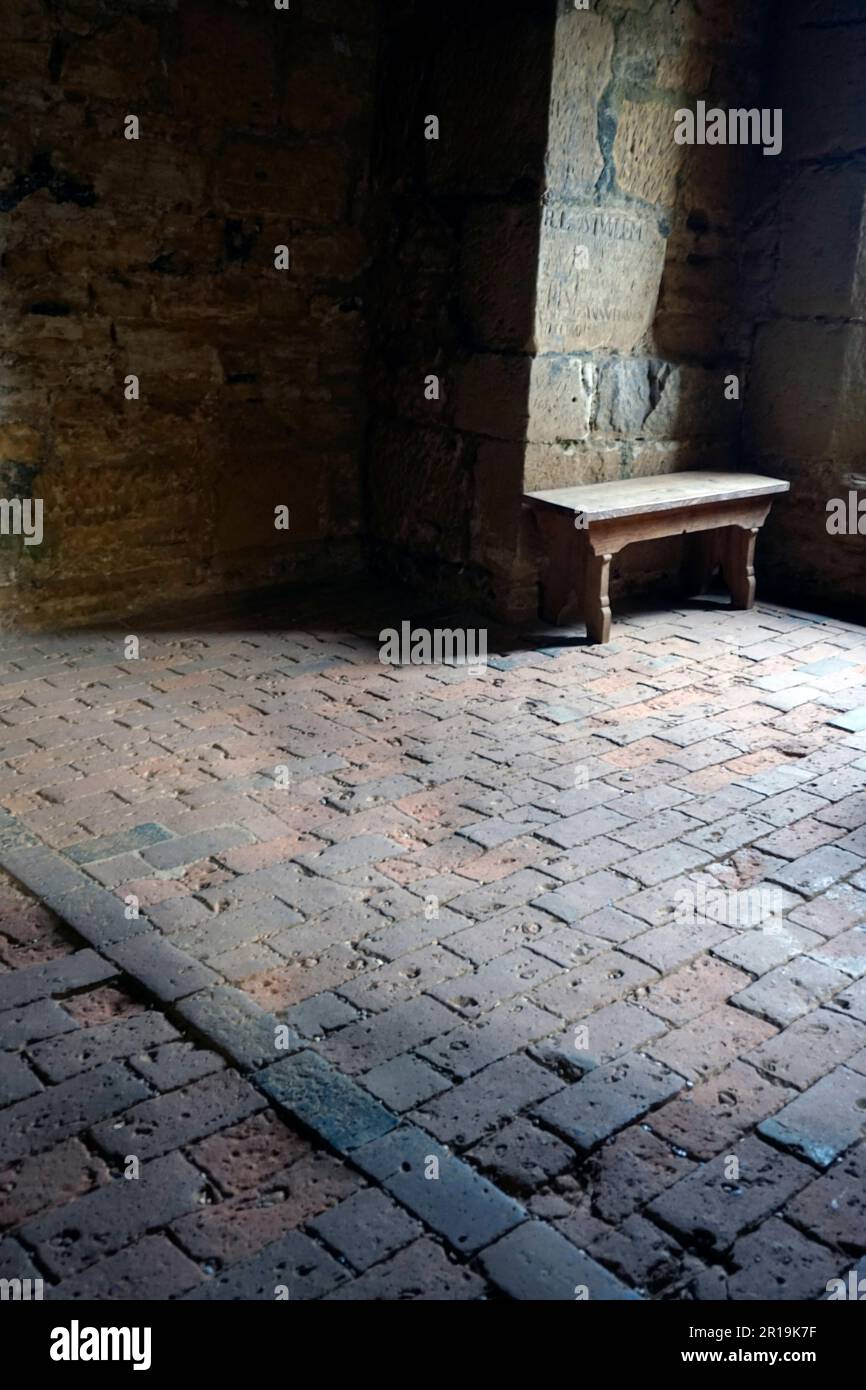 brick floor and single rustic artisanal wooden bench inold castle ...
