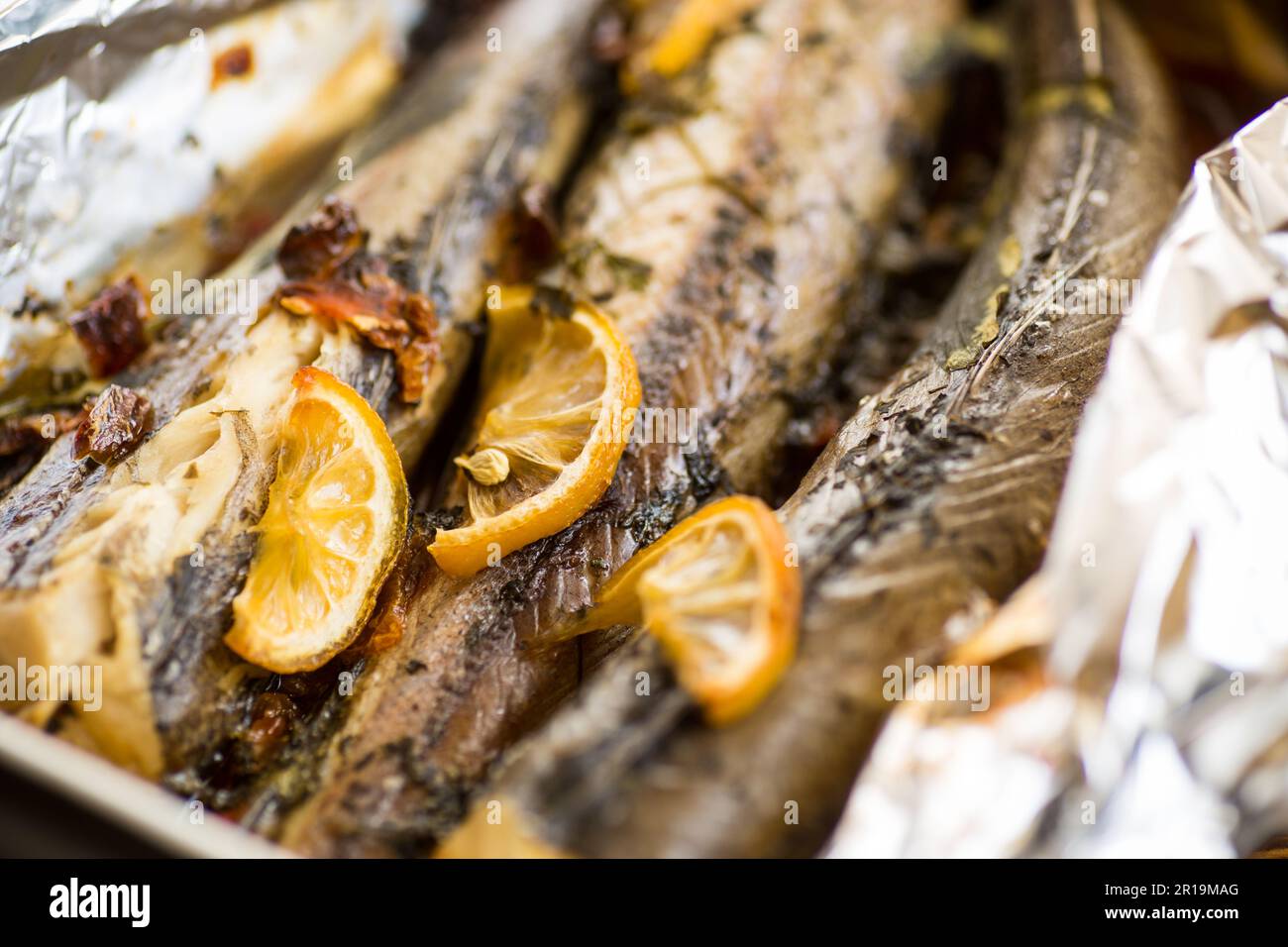 Baked fish with seasonings and spices in foil, in a ceramic form Stock ...