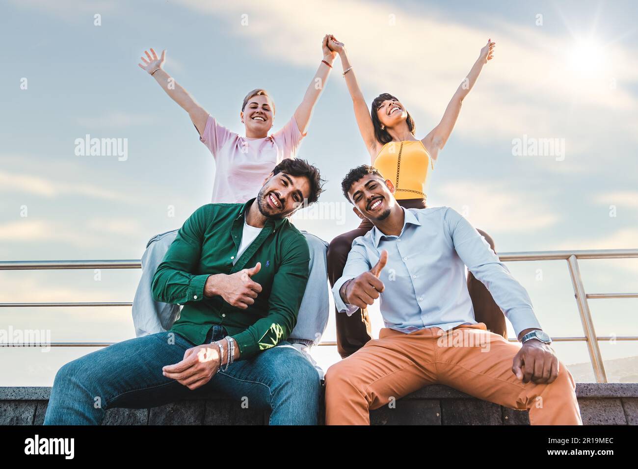 A group of four multicultural friends at the waterfront. The two men ...