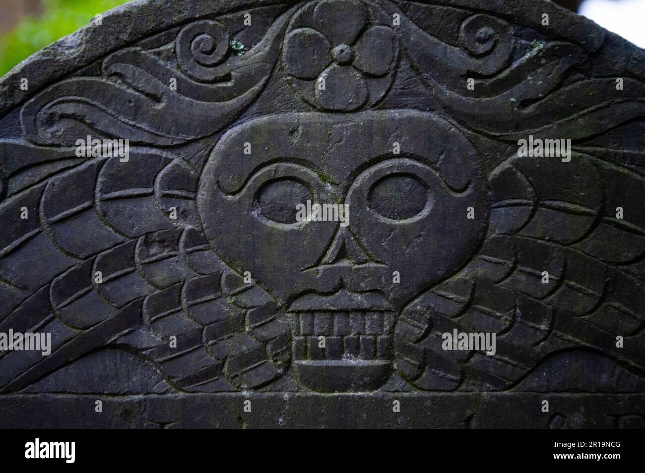 A winged death head tombstone is seen at the Old Parish Cemetery in ...
