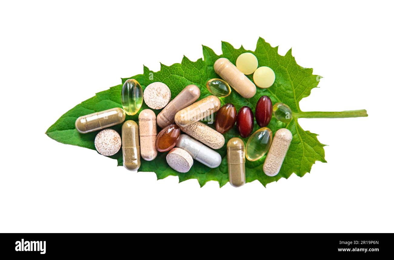 Herb supplement capsules on green leaf isolate on white background ...