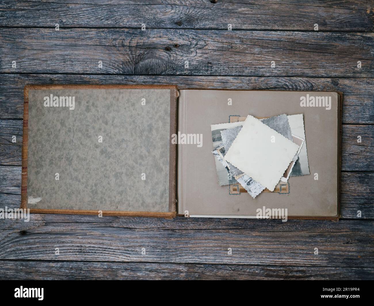 Vintage home photo album open on dark wooden table. The subject of ...