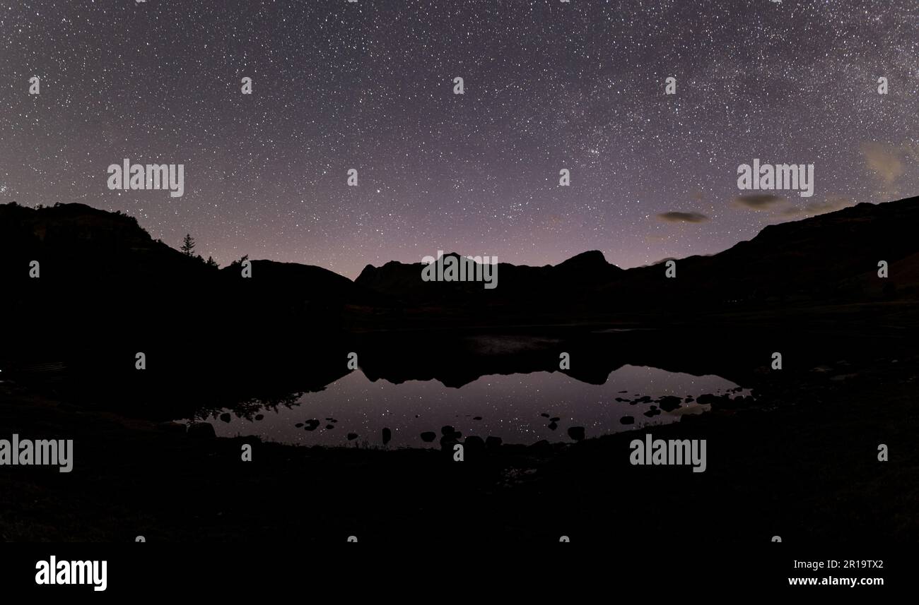 A Panoramic view of the night sky over Blea Tarn in the English Lake ...