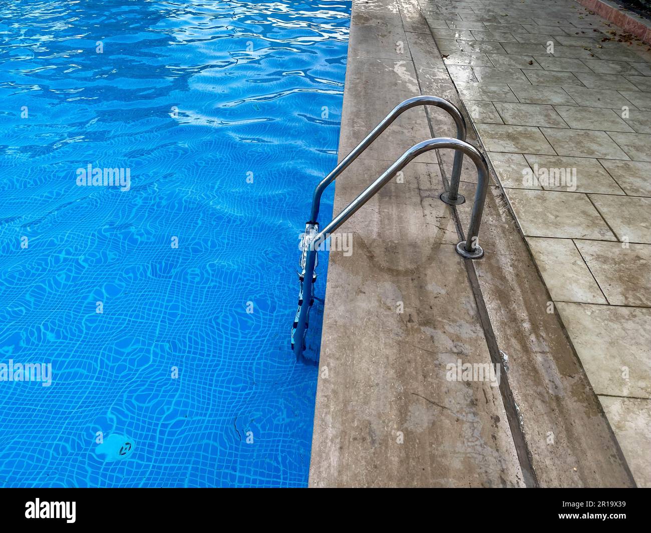Chrome-plated metal staircase with railing to descend into the pool for ...