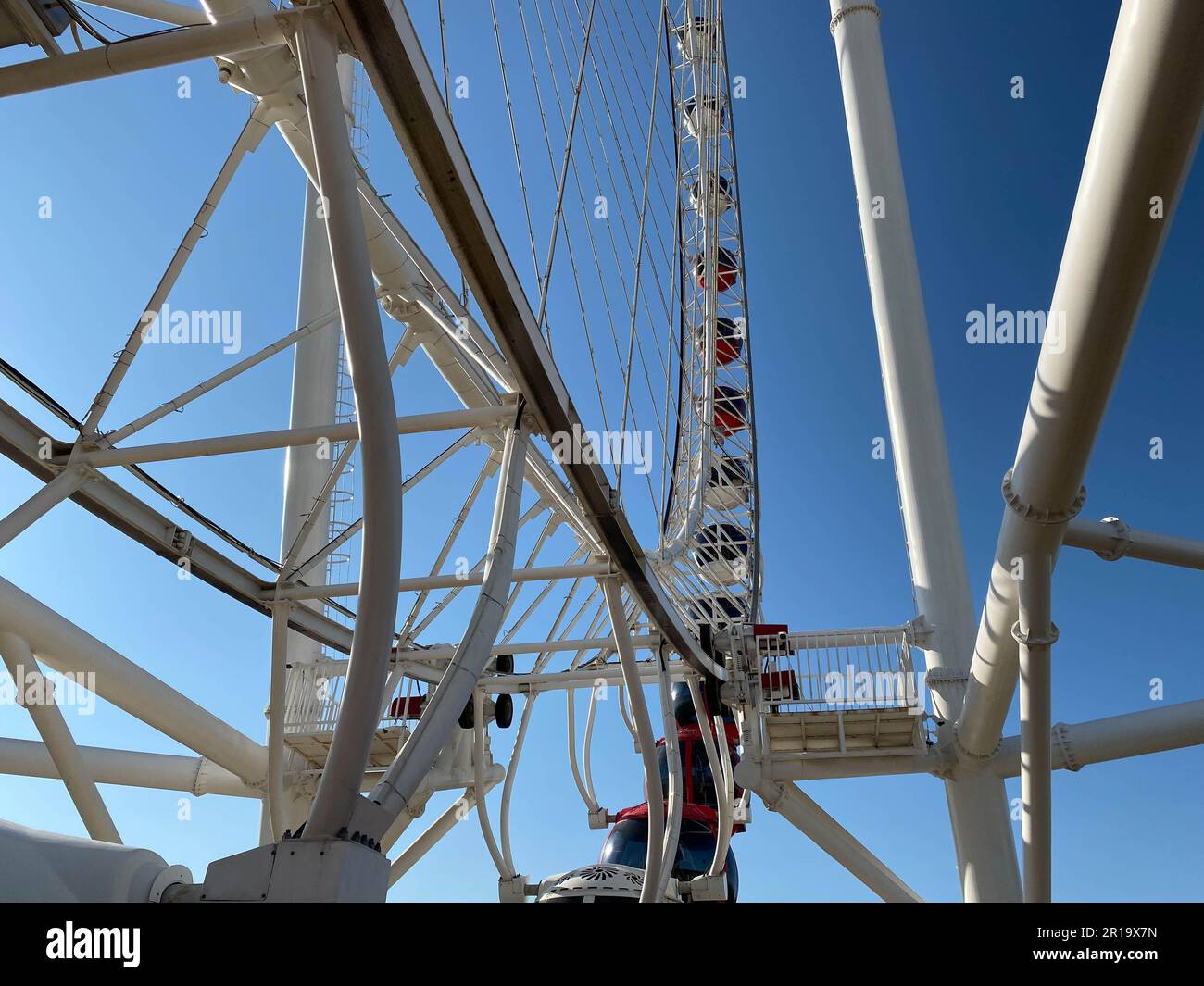 Big white ferris wheel against the blue sky. Part of the attraction on ...