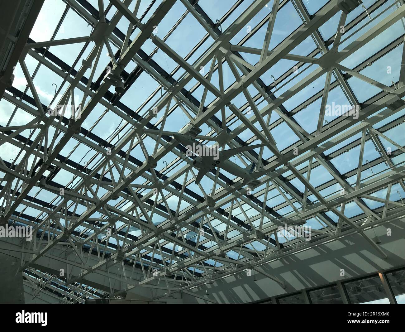 The glass ceiling of the modern building supports a steel beams grid ...