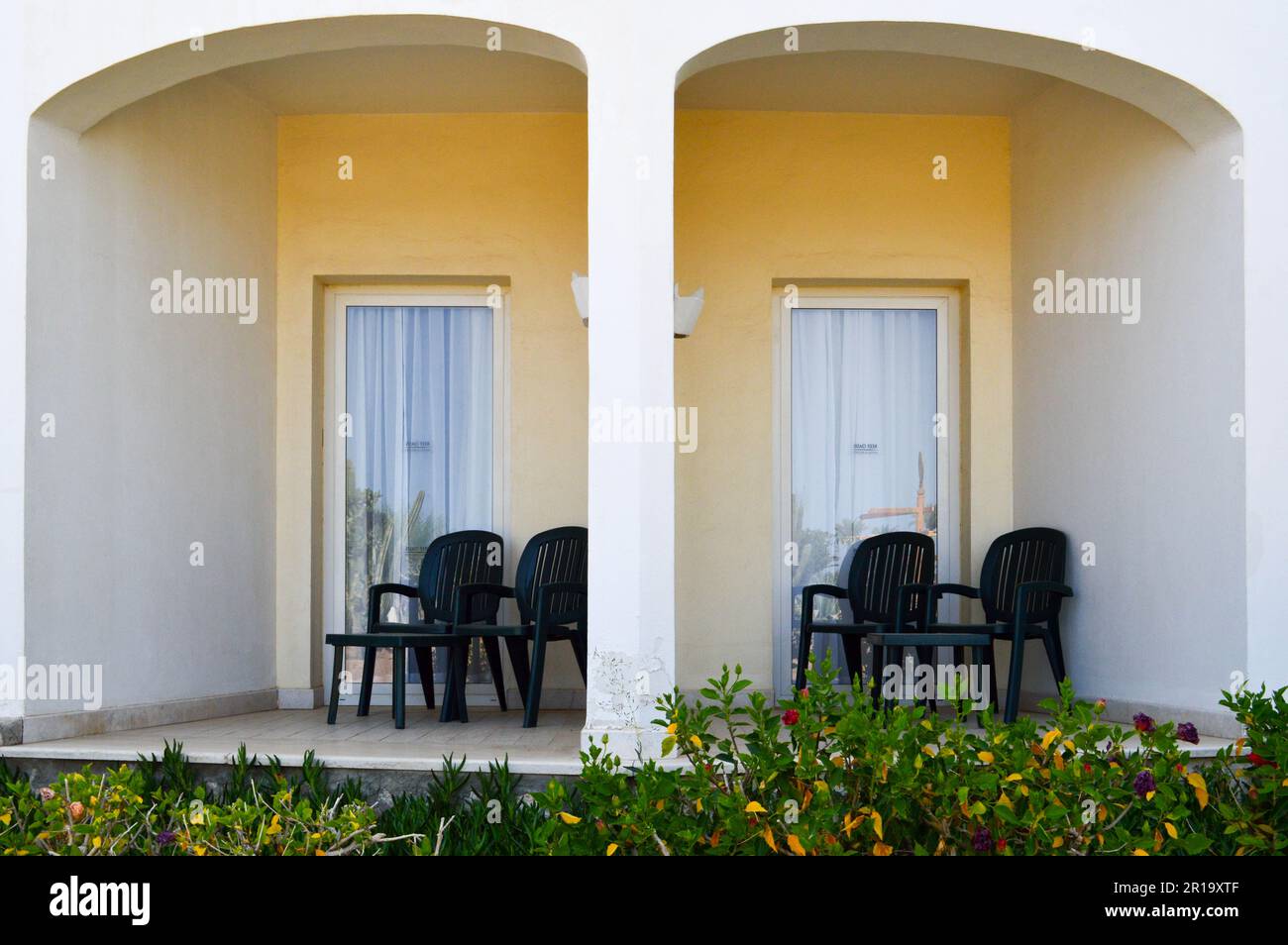 Terrace of a white stone country house with glass doors with plastic ...