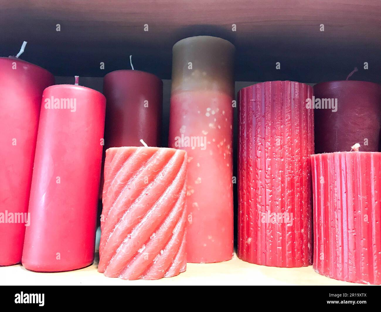 Texture of many festive different forms of red, burgundy wax candles ...