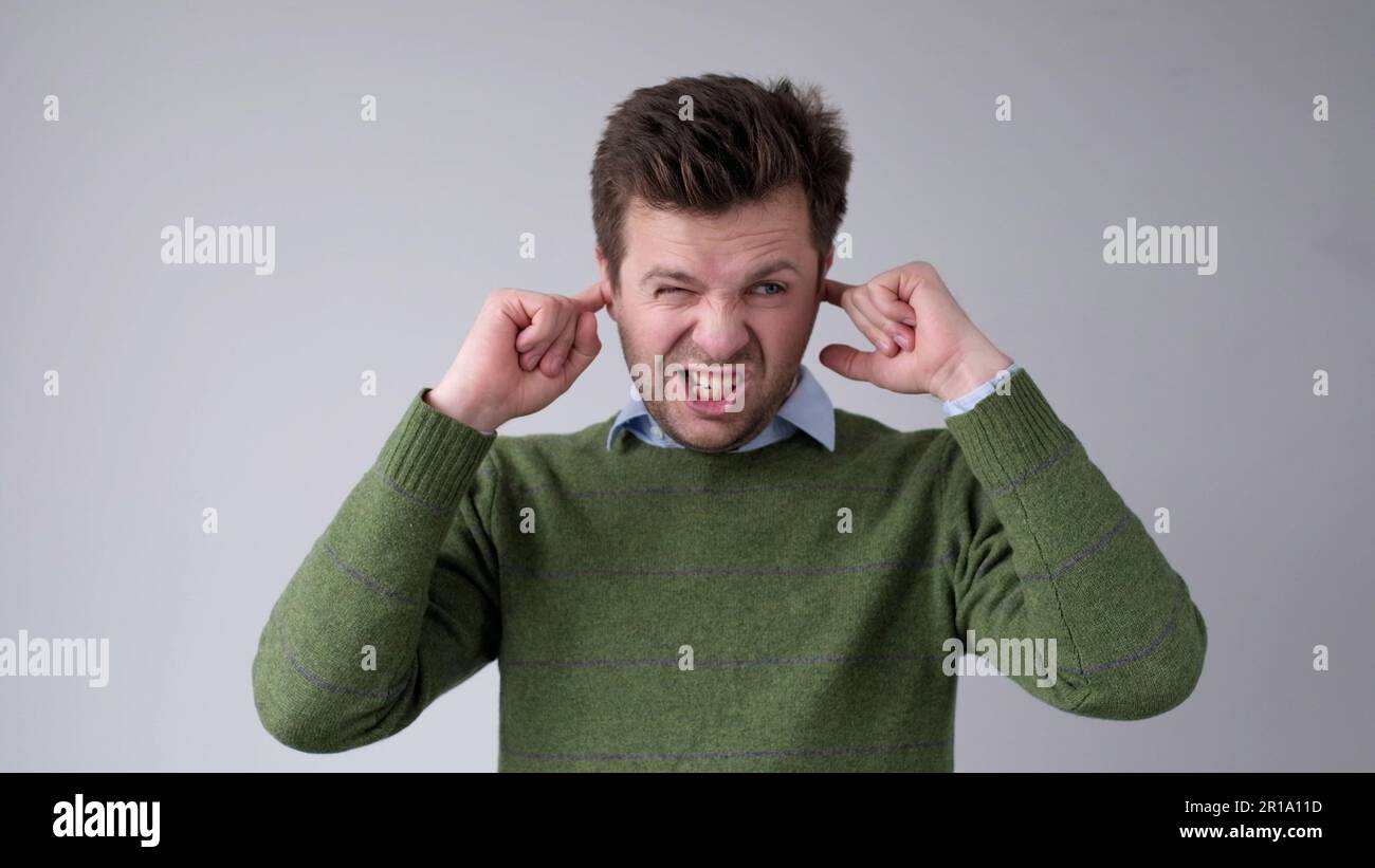 The European young man covers his ears. He doesn't want to hear the ...