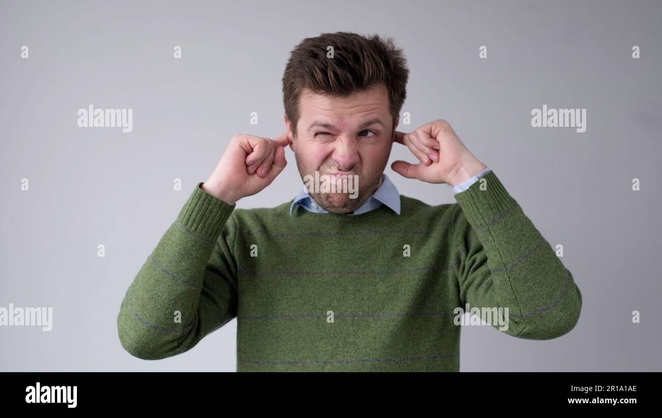 The European young man covers his ears. He doesn't want to hear the ...