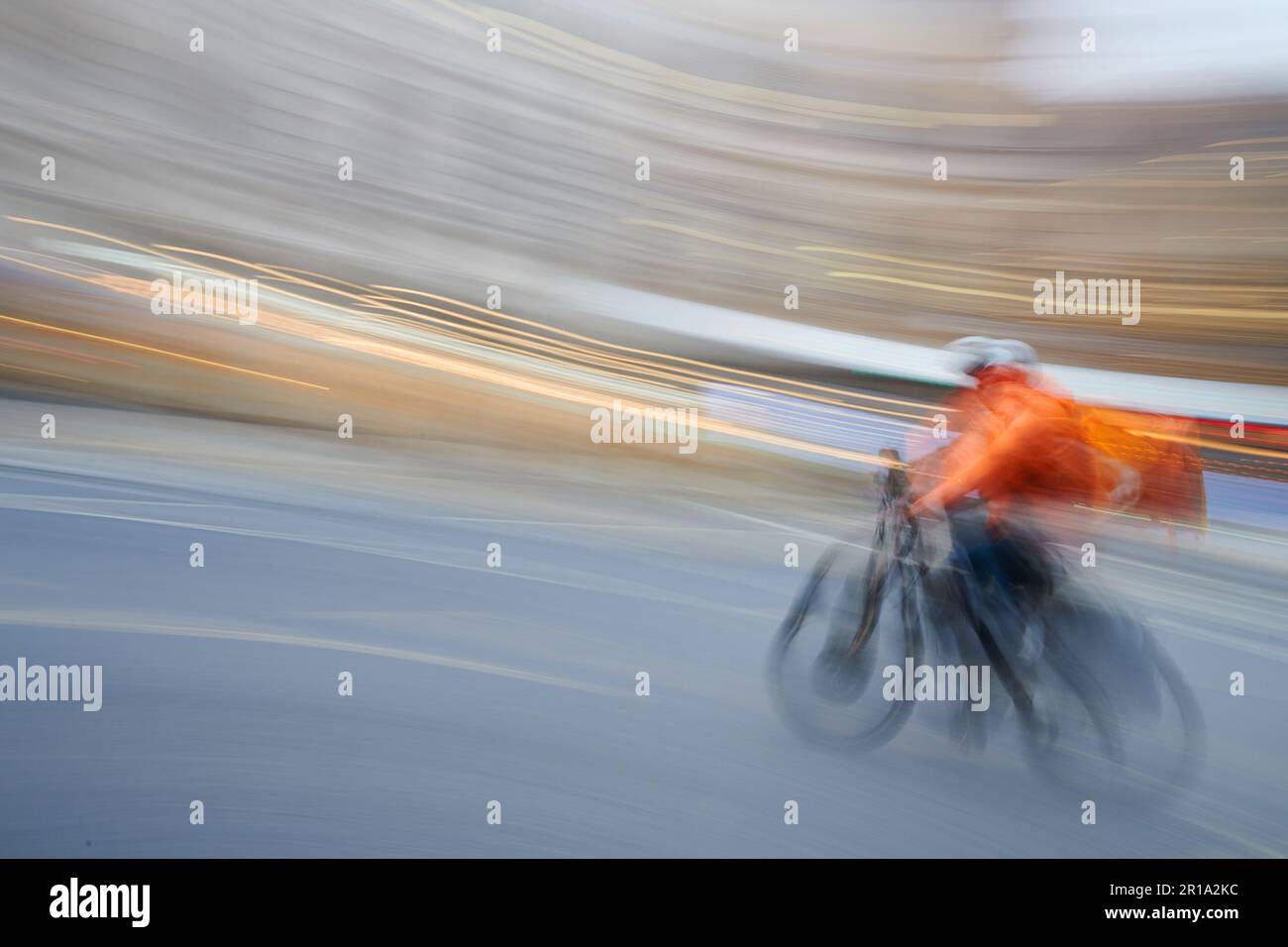 Cyclist passing by. Shot with long exposure to create motion blur and a ...