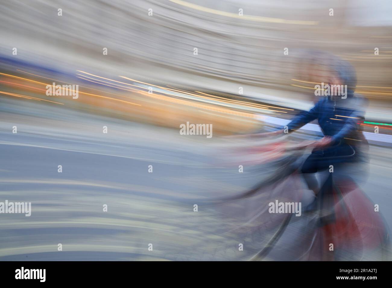 Cyclist passing by. Shot with long exposure to create motion blur and a ...