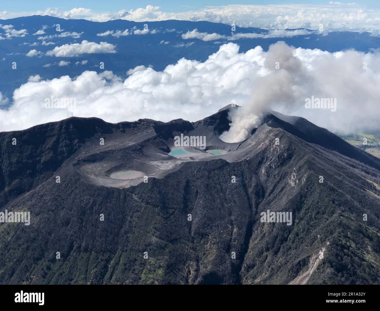 Aerial view of an active volcano with billowing clouds in the ...