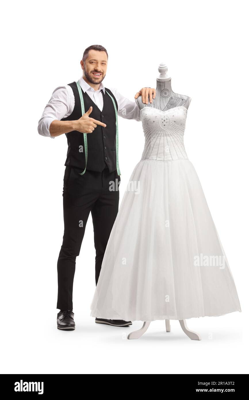 Tailor standing next to a bridal gown on a doll mannequin and pointing ...