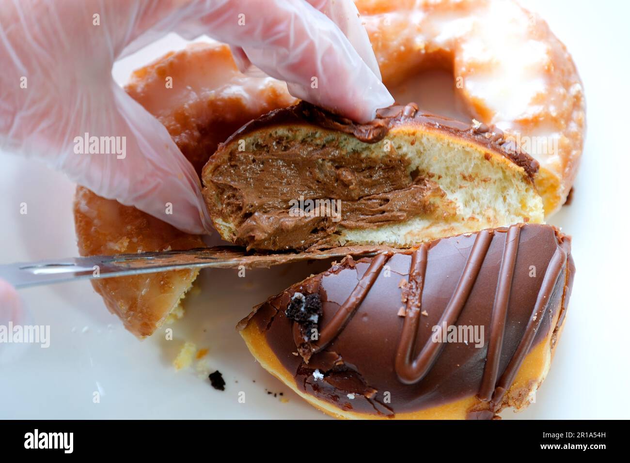 bagel cut in half and spread with cream cheese, placed on a plate with ...