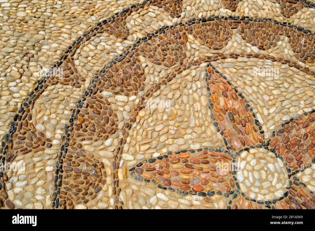 The texture of the stone wall, the road from small round and oval ...