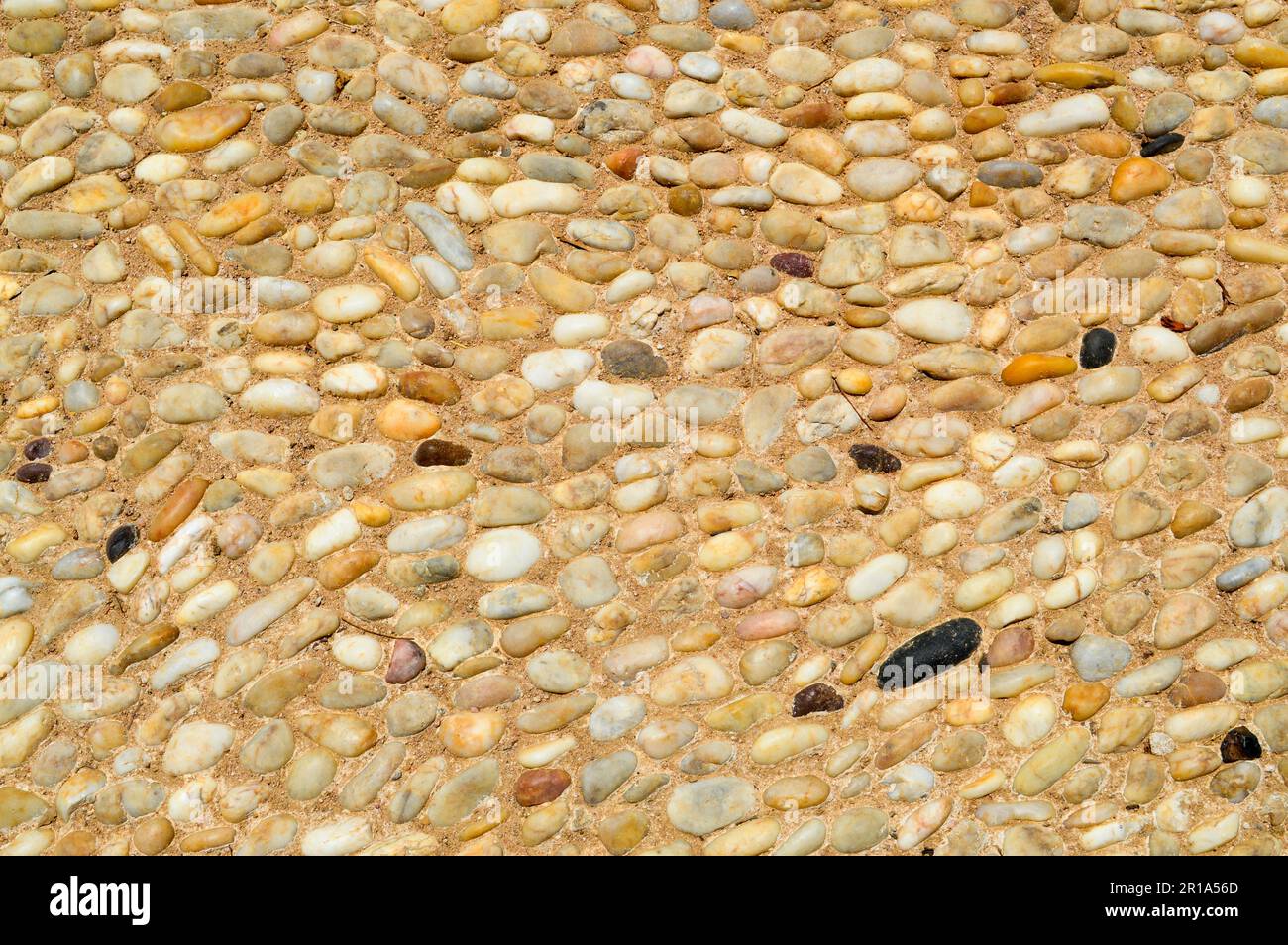 Texture of a stone wall, roads from small round and oval stones with ...