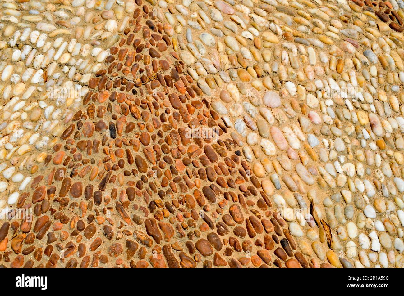 The texture of the stone wall, the road from small round and oval ...