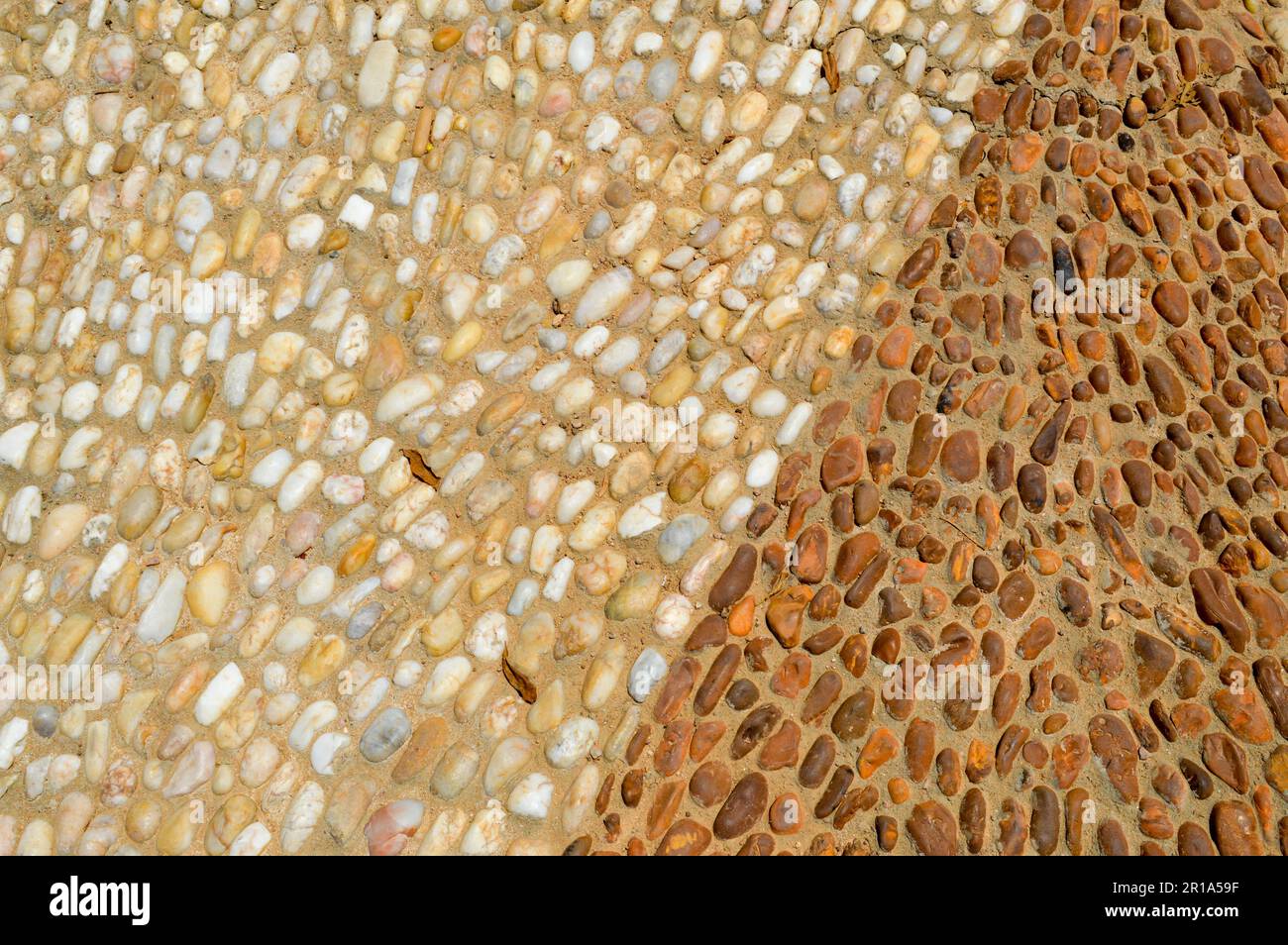 The texture of the stone wall, the road from small round and oval ...