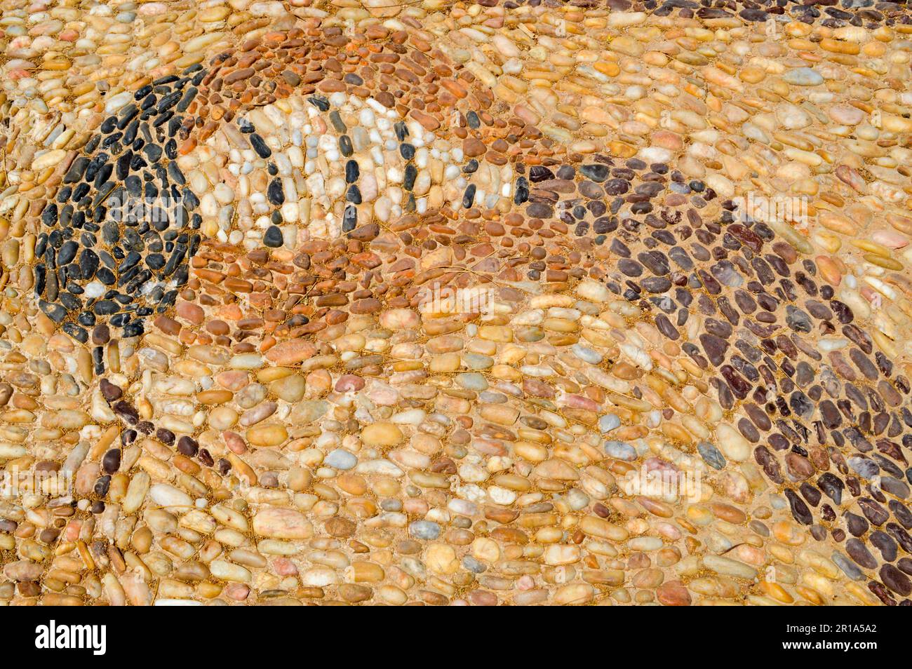 The texture of the stone wall, the road from small round and oval ...