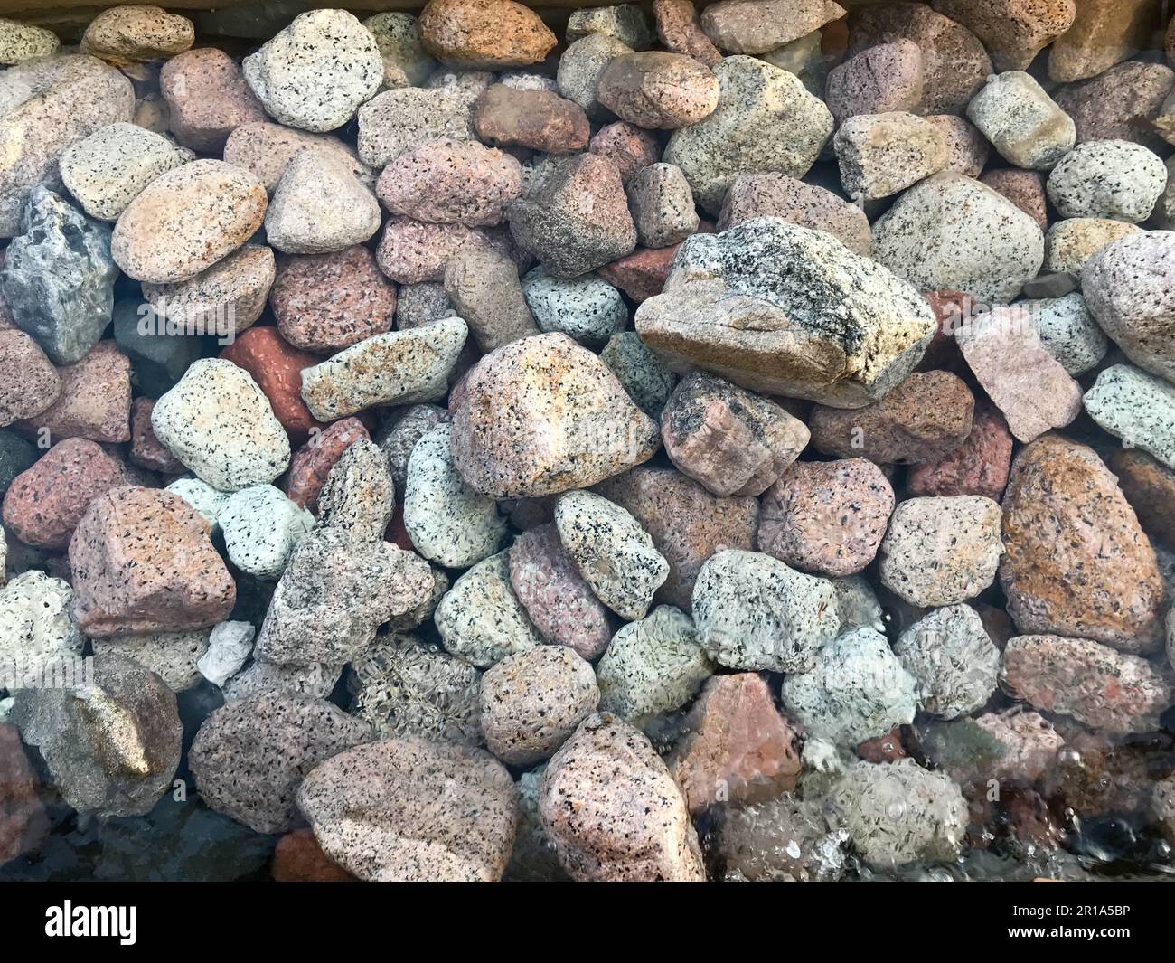 A beautiful texture of multi-colored round and oval natural solid stone ...