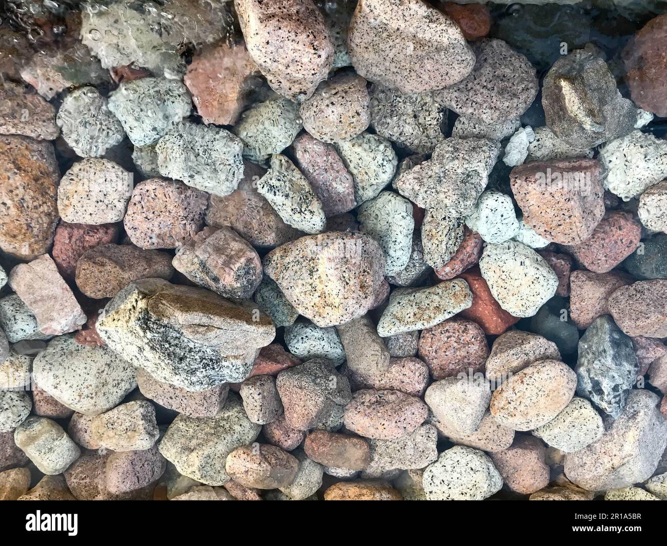 A beautiful texture of multi-colored round and oval natural solid stone ...