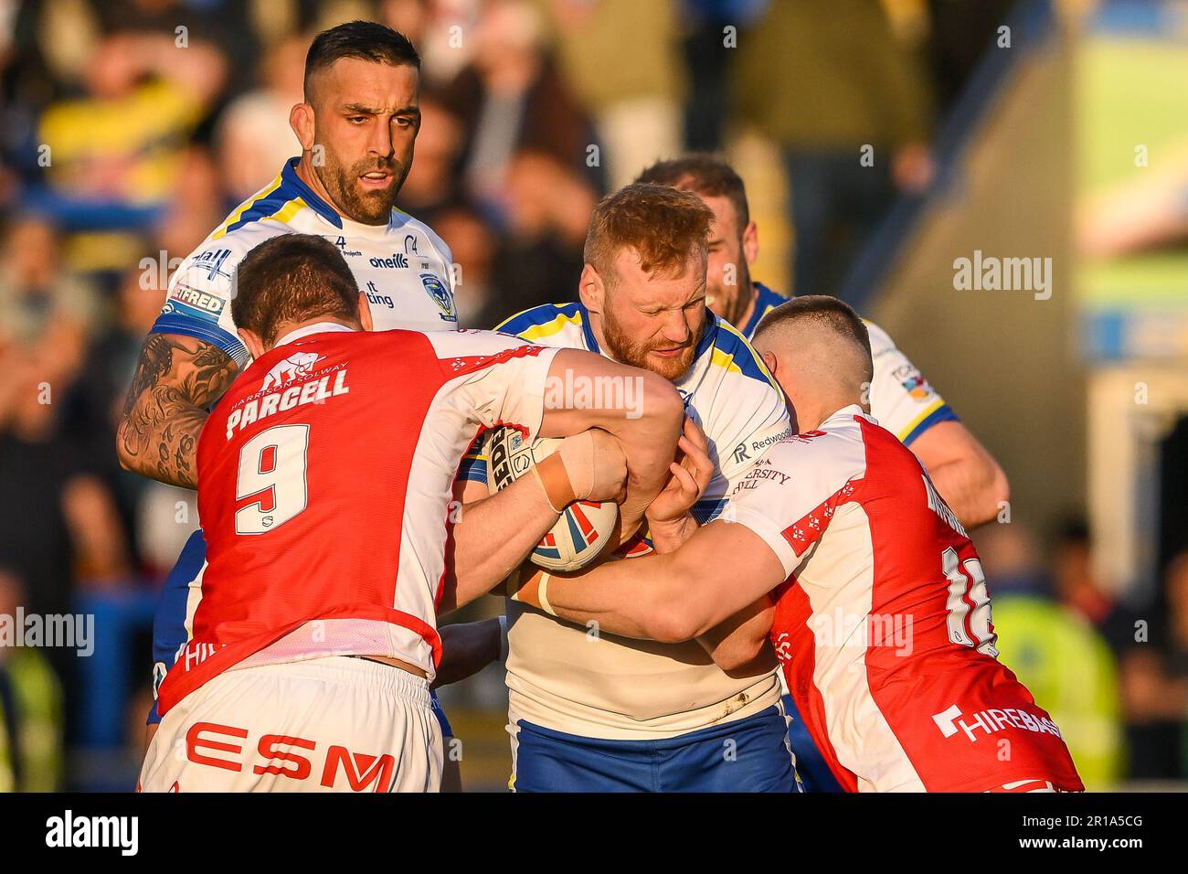 Joe Bullock #19 of Warrington Wolves is tackled by Matt Parcell #9 and ...