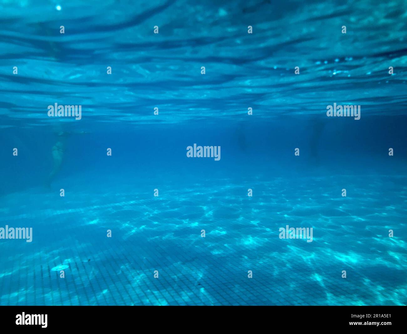 View swimming pool with ceramic tiles under blue water, underwater view ...