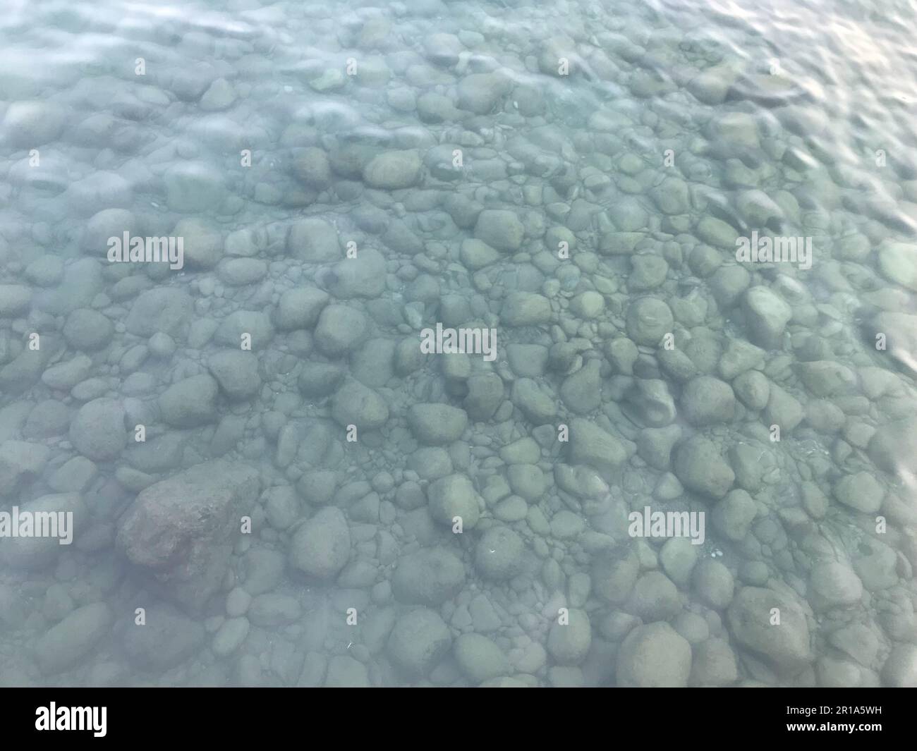 Sea stones in the sea water. Pebbles under water. The view from the top ...