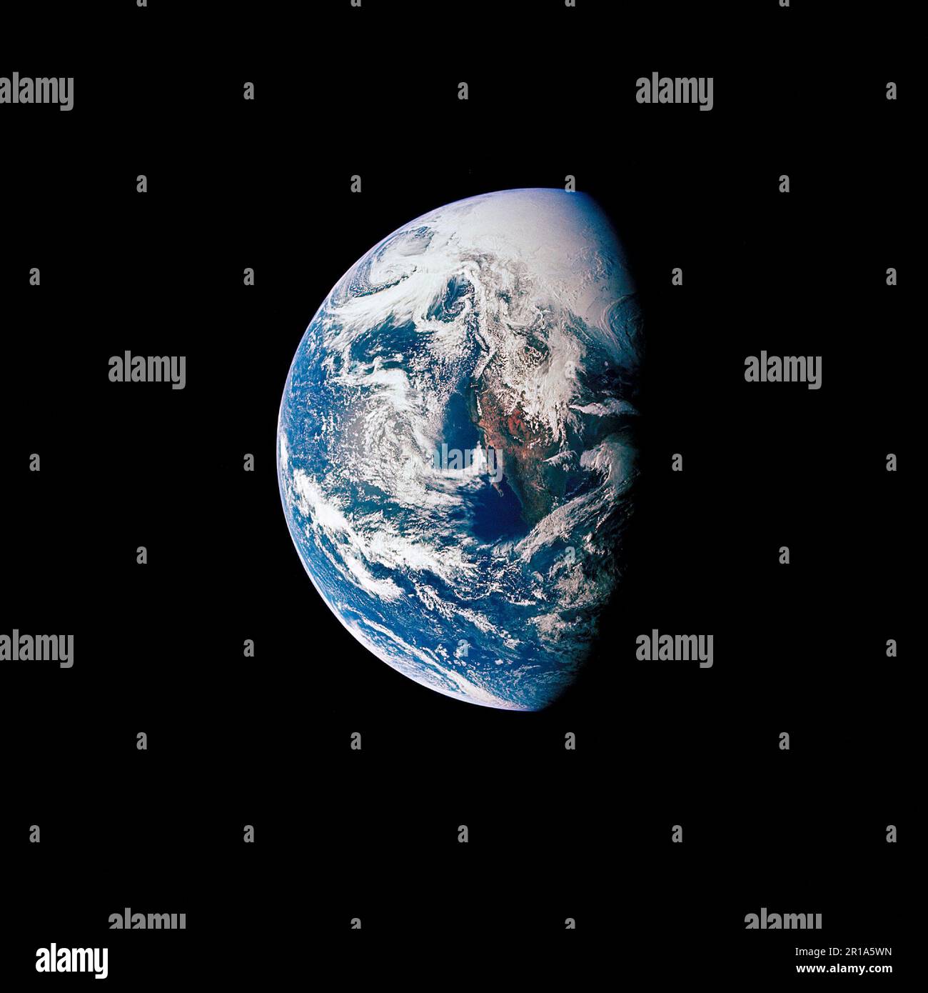 The planet Earth seen from space half-covered in sun light against a ...