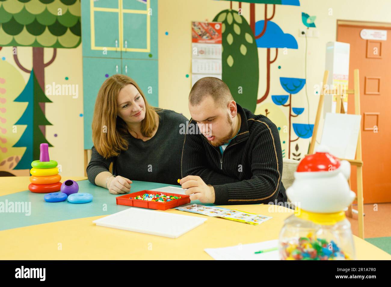 a psychologist is engaged with an autistic man with mental disabilities ...