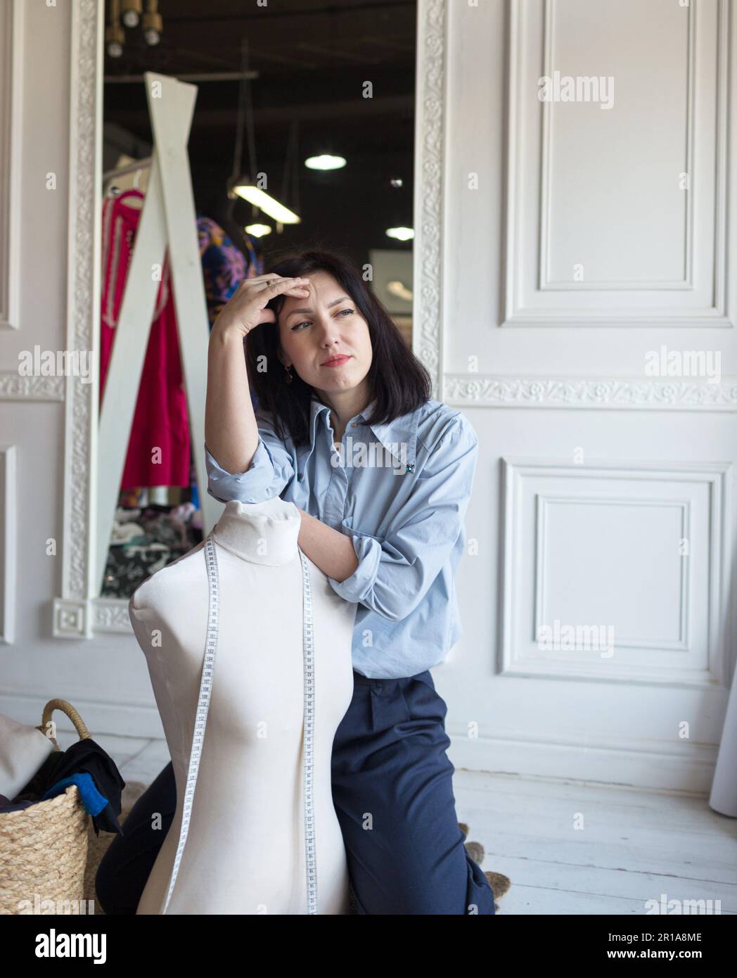 a designer girl creates clothes in an atelier, measures by a centimeter ...