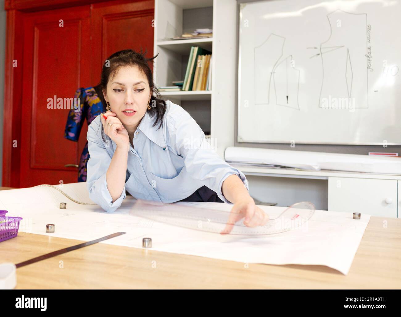 The designer-seamstress makes precise measurements for sewing clothes ...