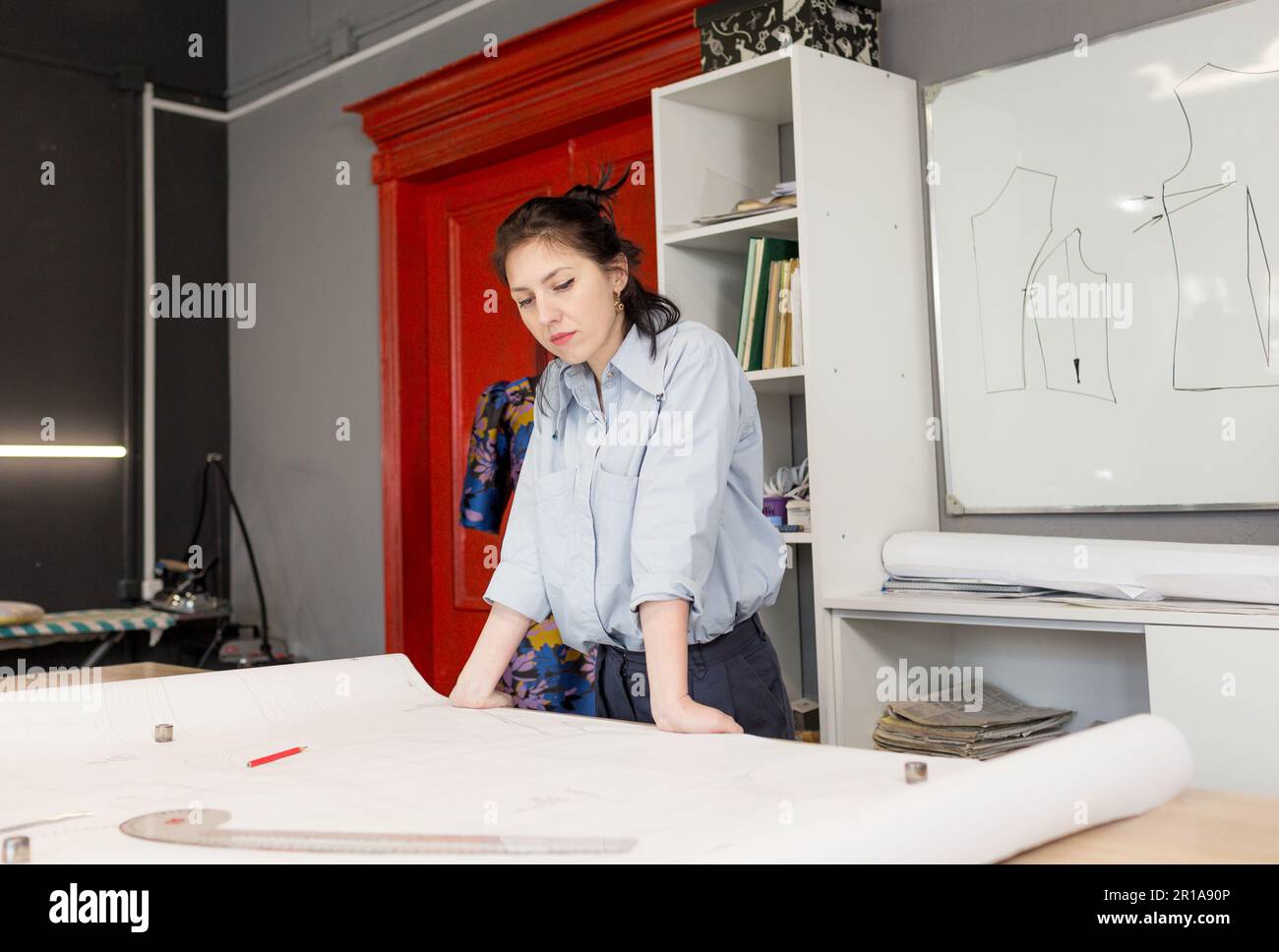 The designer-seamstress makes precise measurements for sewing clothes ...