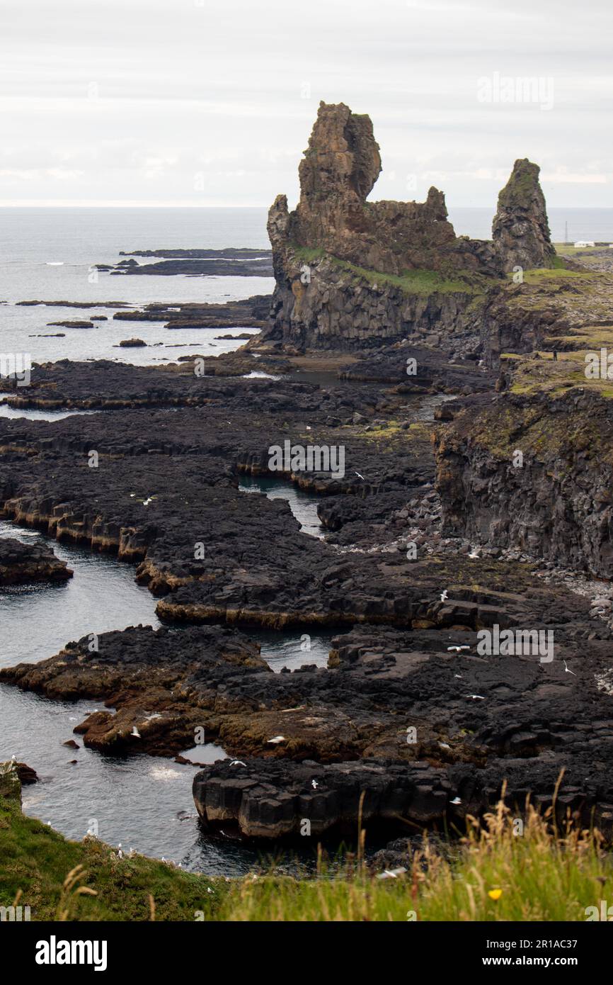 Black rocky cliffs in Iceland with water and horizon Stock Photo - Alamy