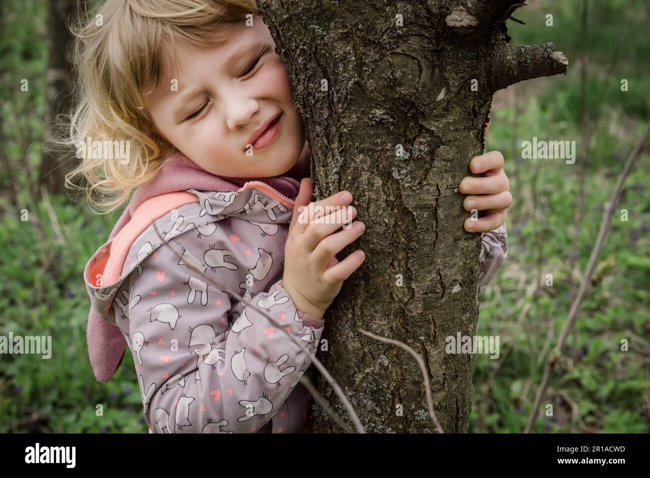 Harmonized with nature. Girl feels harmony with nature, hugging tree ...