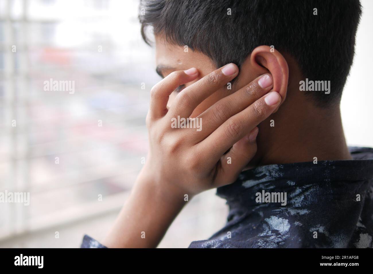 teenage boy having ear pain touching his painful ear Stock Photo - Alamy