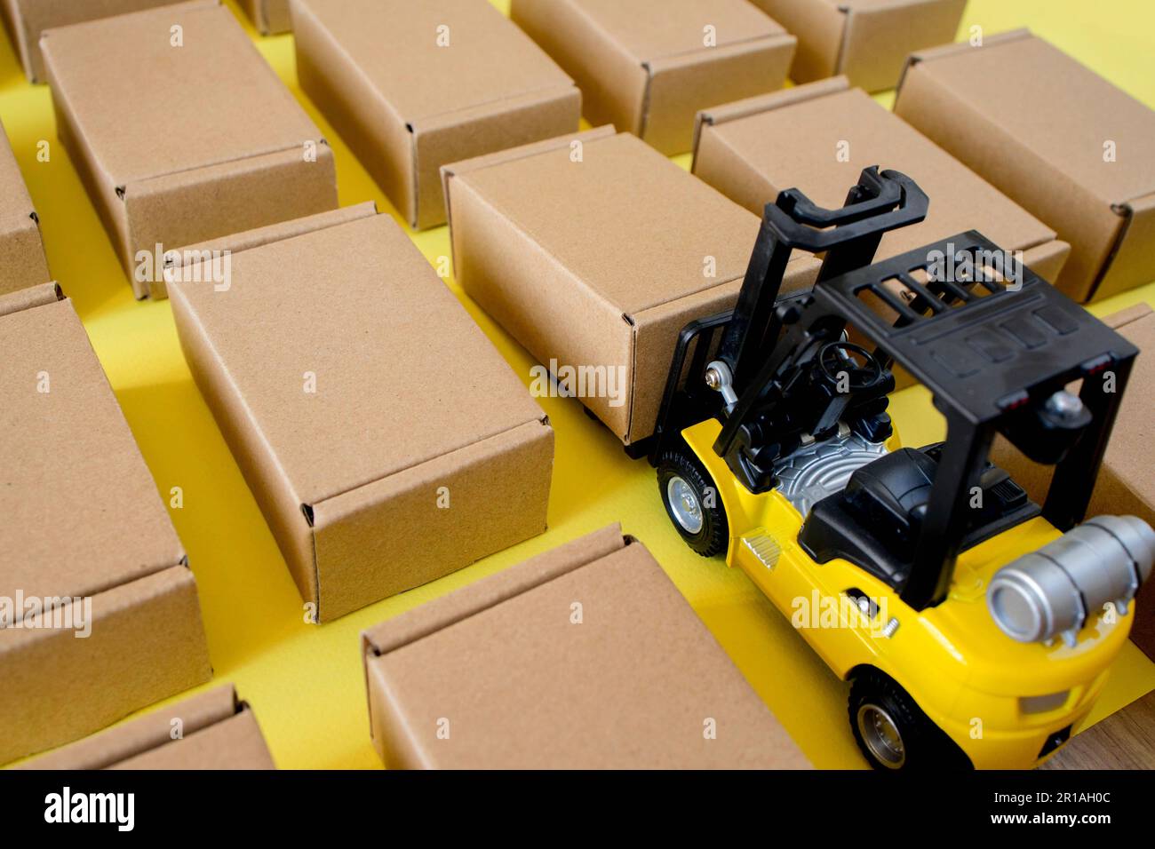 Forklift truck raises cardboard boxes on a yellow background. Cargo ...