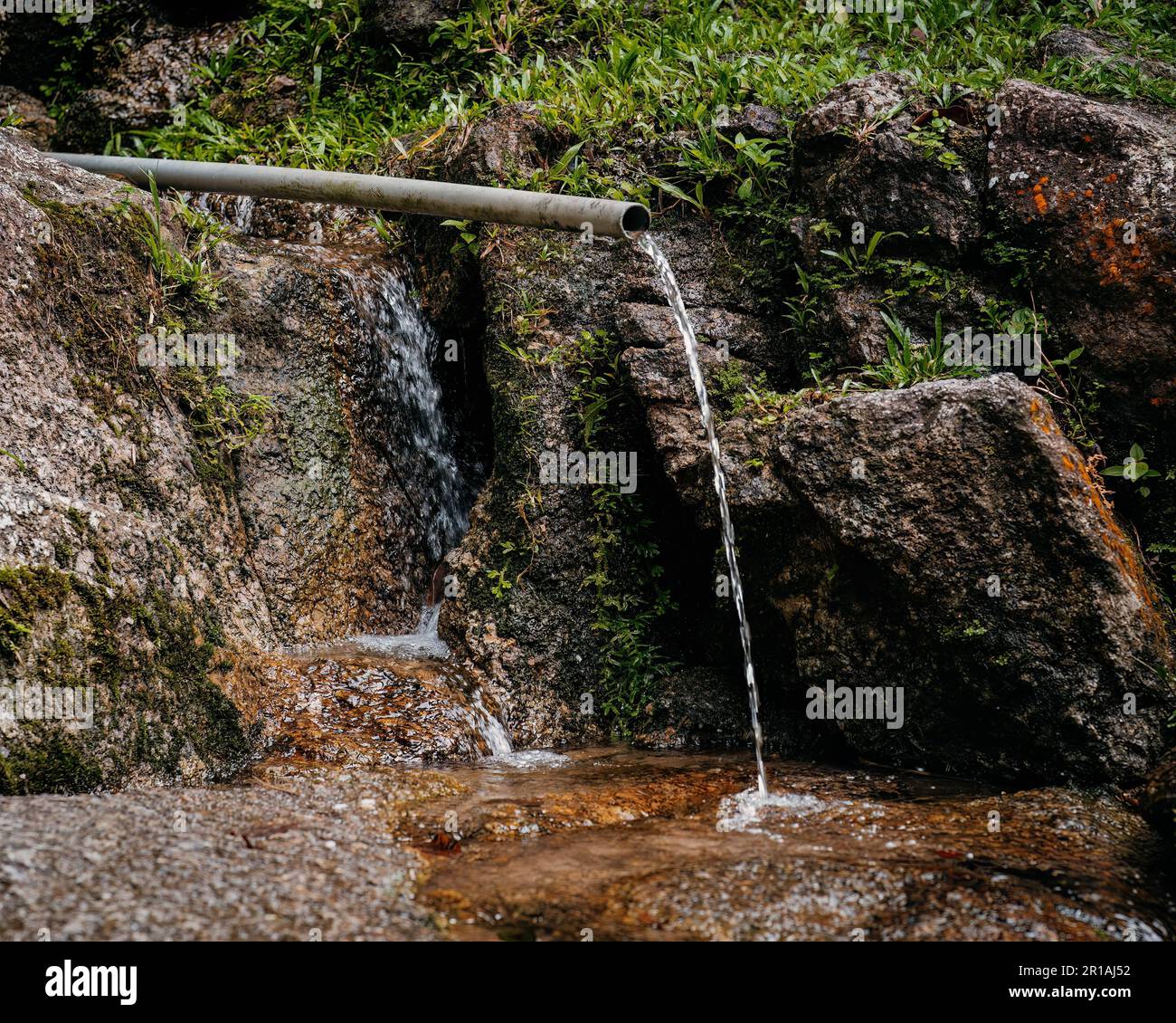 A water pipe running alongside a peaceful creek is releasing a constant ...